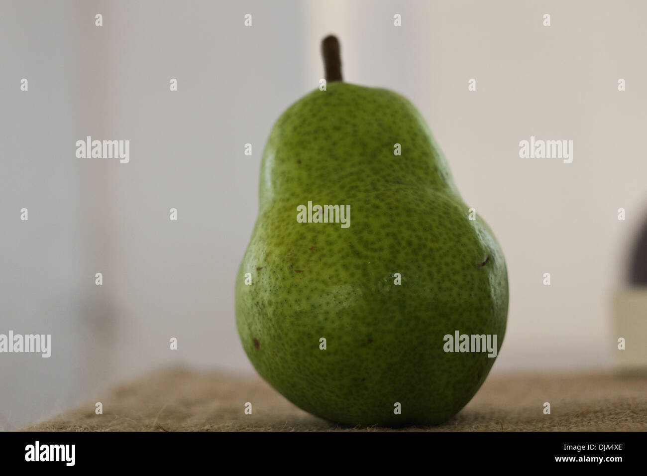 A green pear on a dinner table Stock Photo - Alamy