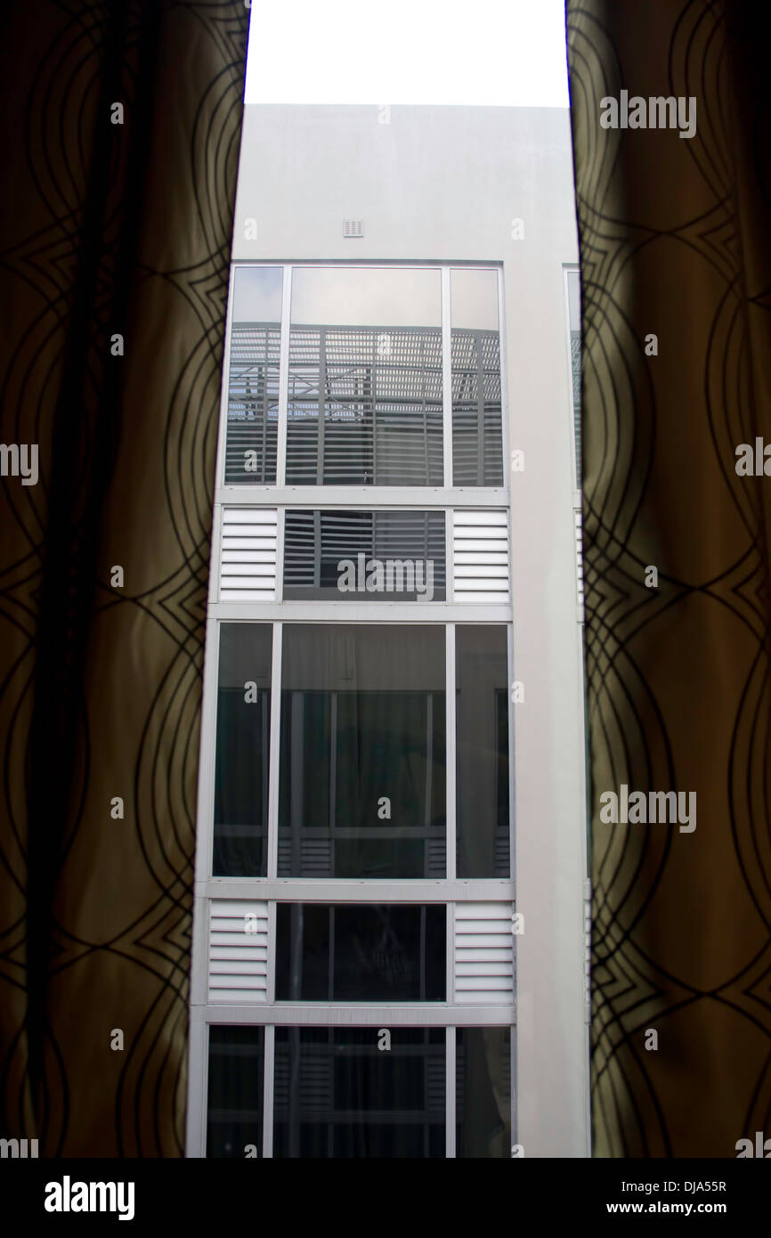 Windows of opposite building viewed through curtains, with multiple ...