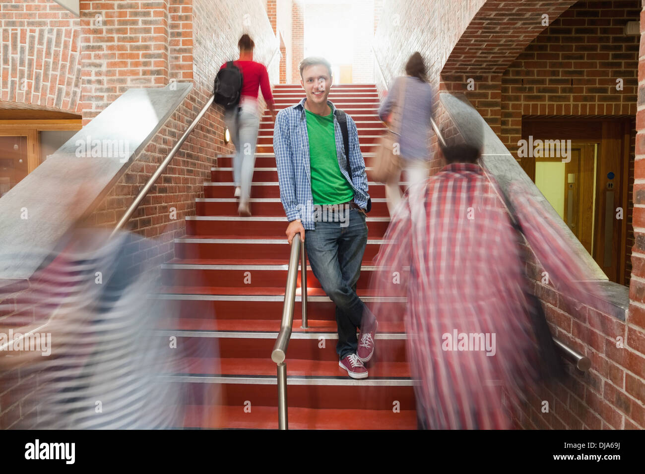 Casual handsome student standing on stairs Stock Photo - Alamy
