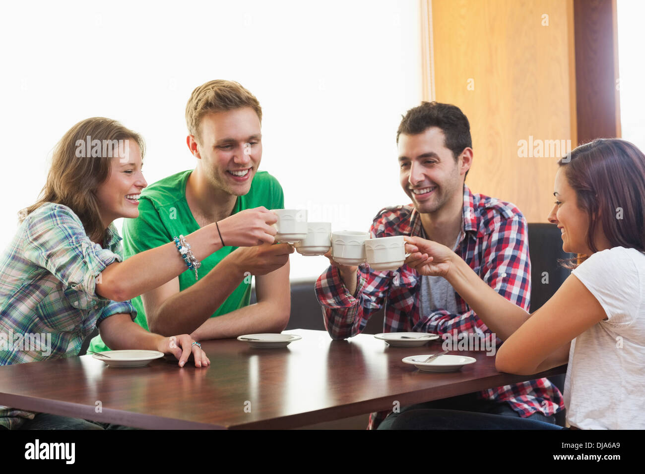 Four casual students drinking a cup of coffee Stock Photo - Alamy