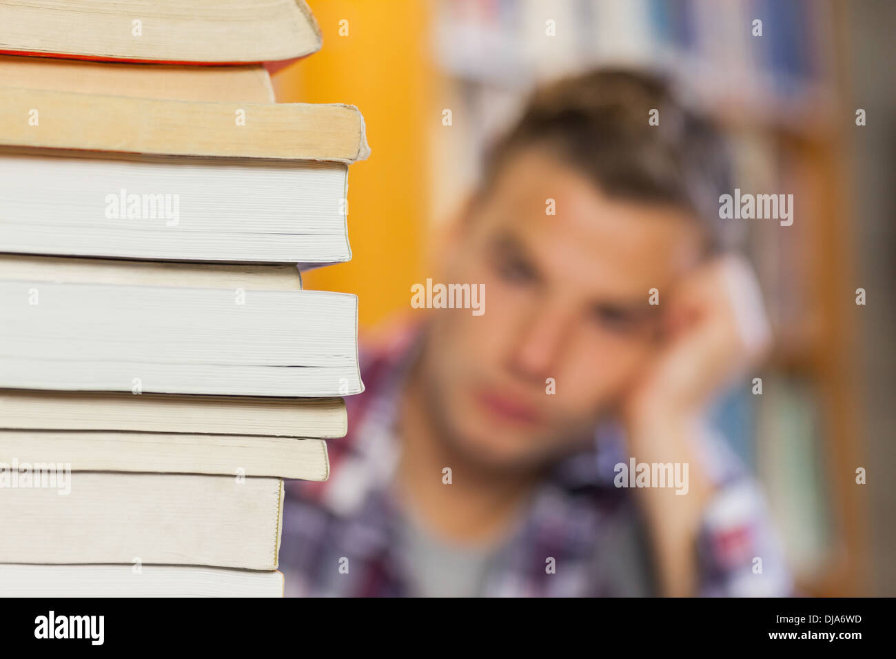 Student studying between piles of books Stock Photo - Alamy