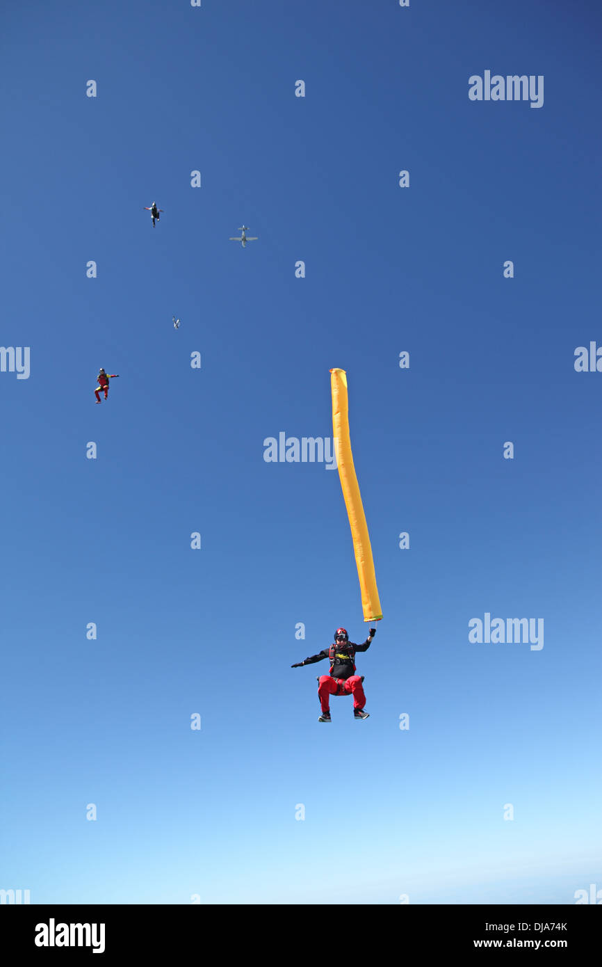 Skydiver with colorful air tube and friends are jumping out of a plane ...