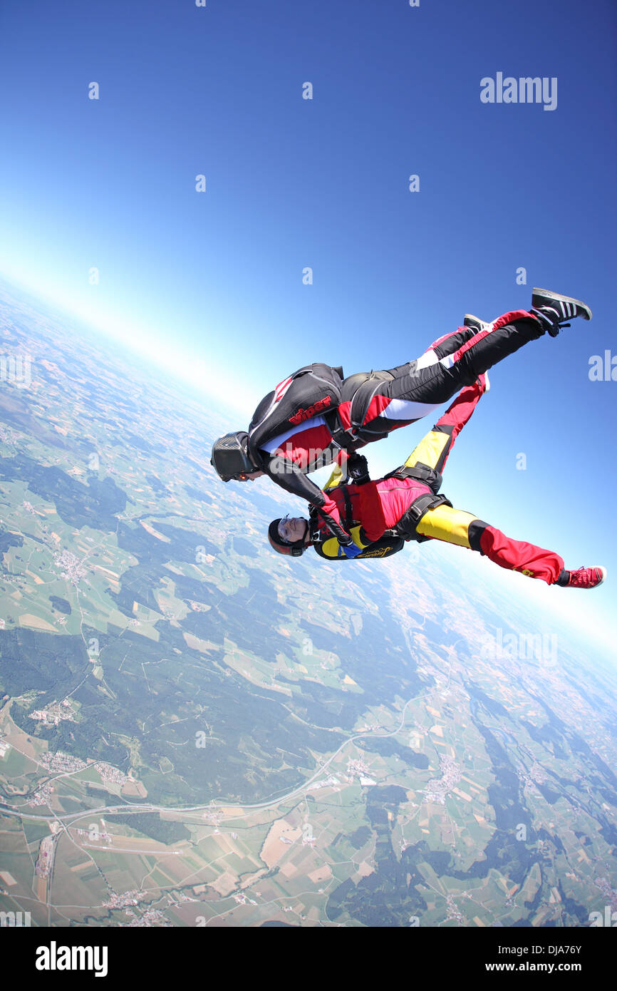 Skydivers are jumping out of an airplane and holding each other in a ...