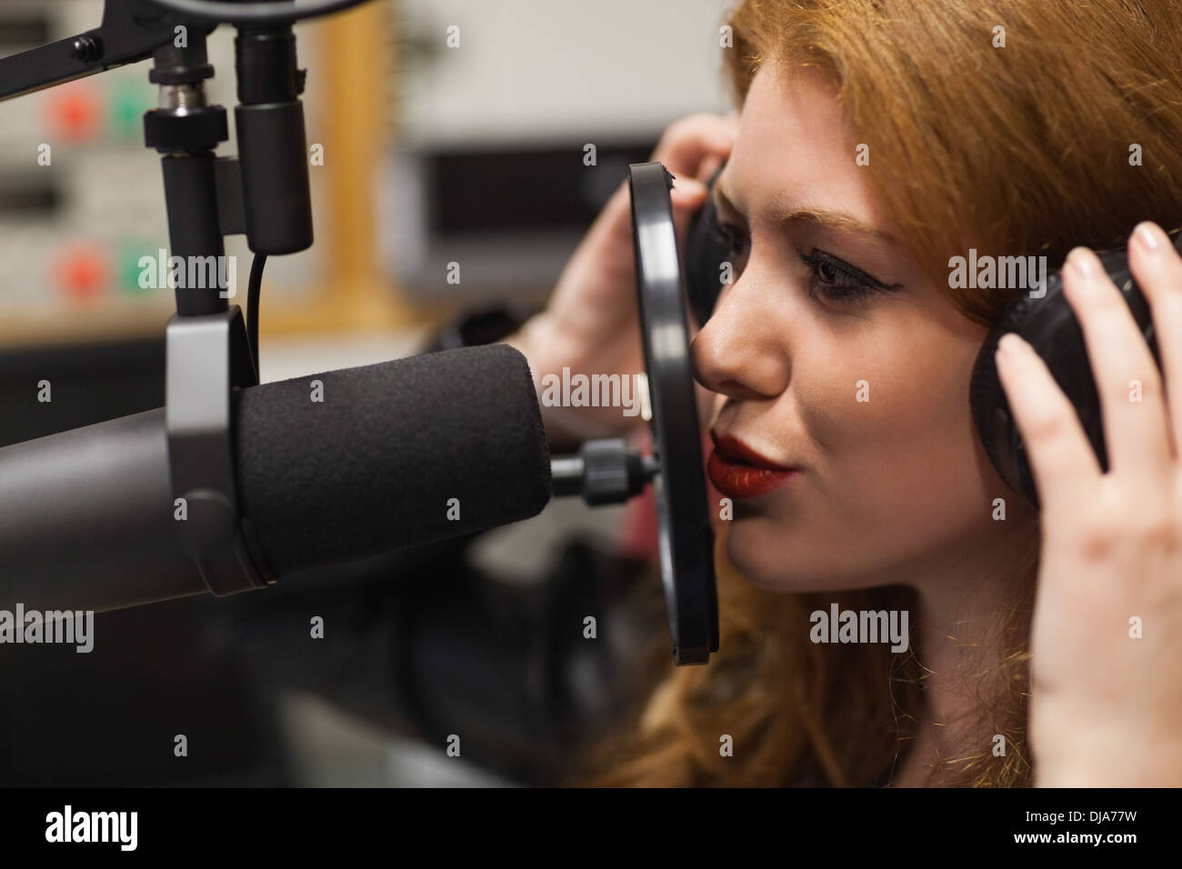 Focused beautiful singer recording a song Stock Photo - Alamy