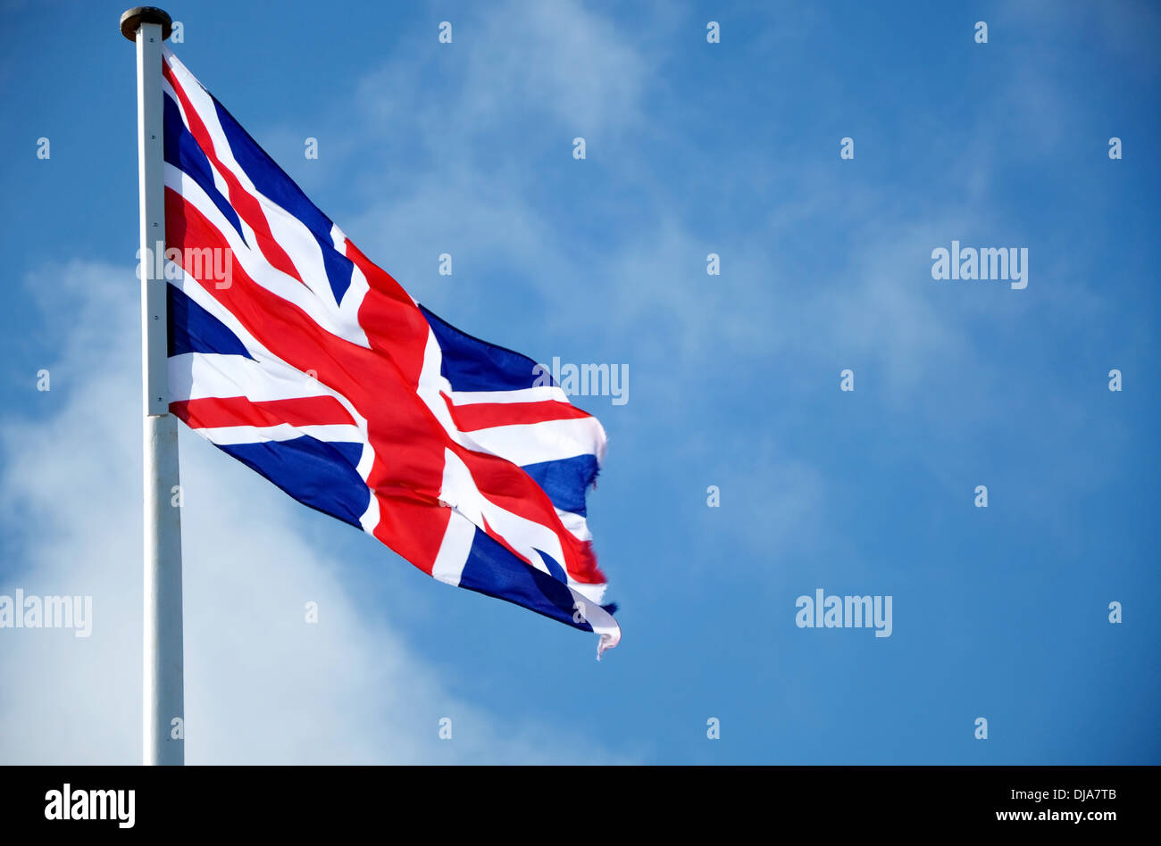 The Union Jack flag of the United Kingdom flying proud against a blue ...