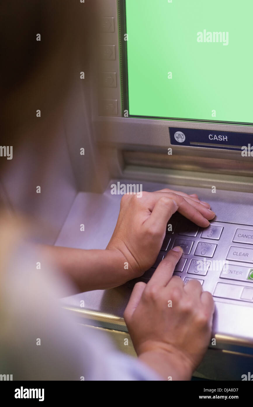 Woman entering pin and covering keyboard at an ATM Stock Photo - Alamy