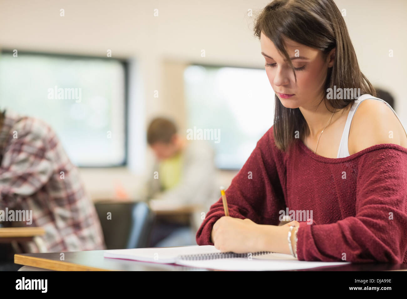 Student writing notes in the classroom Stock Photo - Alamy
