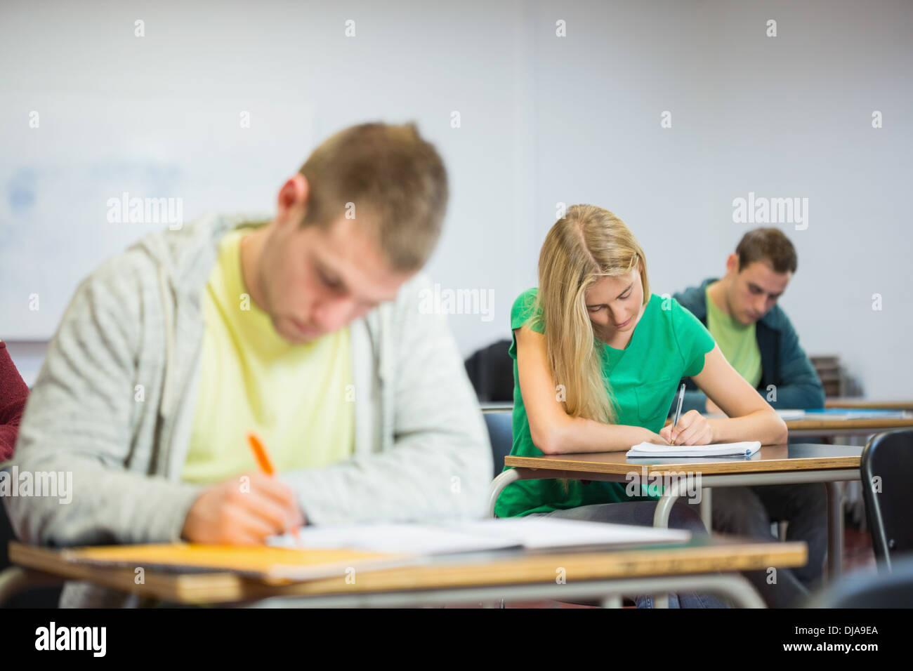 Young students writing notes in classroom Stock Photo - Alamy