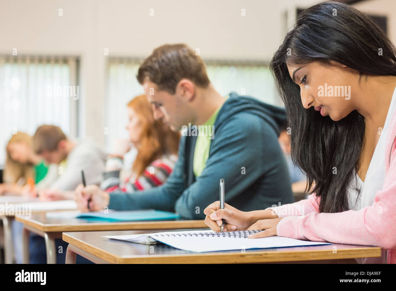 Young students writing notes in classroom Stock Photo - Alamy