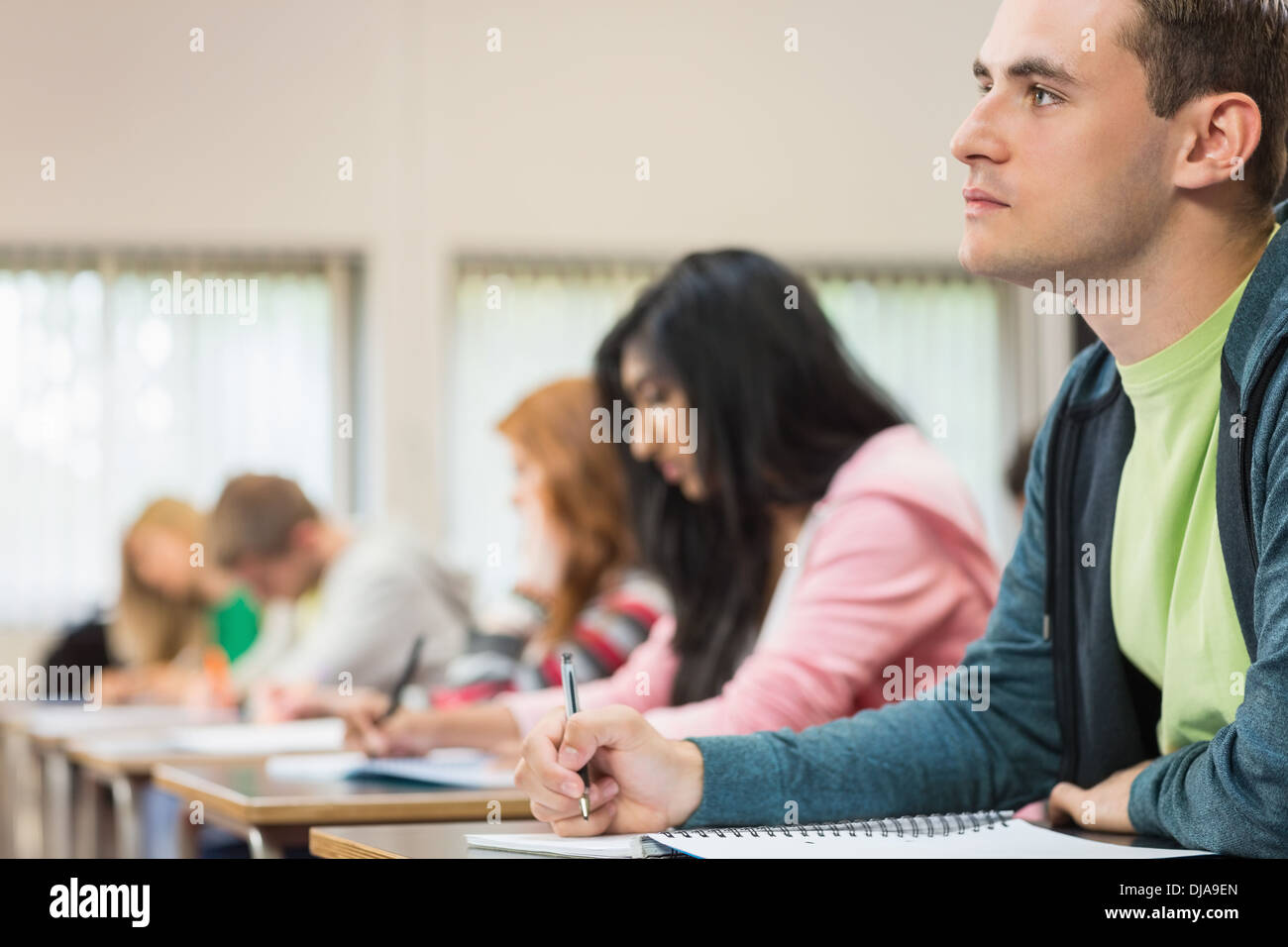 Young students writing notes in classroom Stock Photo - Alamy