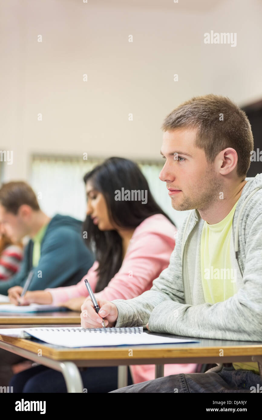Young students writing notes in classroom Stock Photo - Alamy