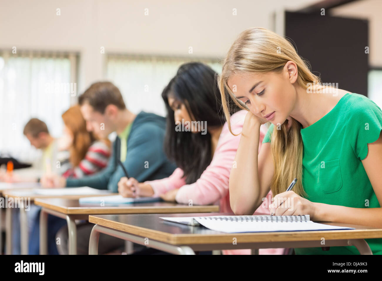 Young students writing notes in classroom Stock Photo - Alamy