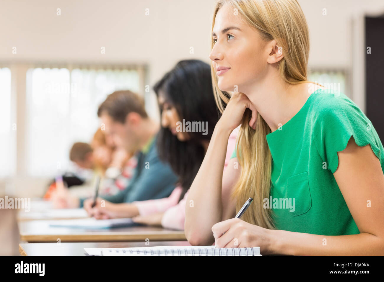 Young students writing notes in classroom Stock Photo - Alamy