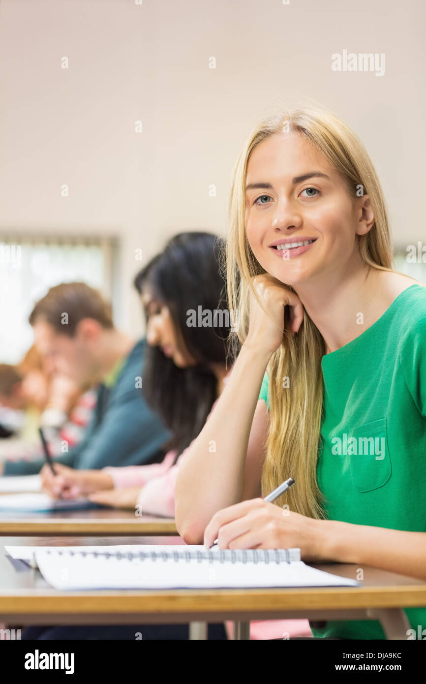 Female student with others writing notes in classroom Stock Photo - Alamy
