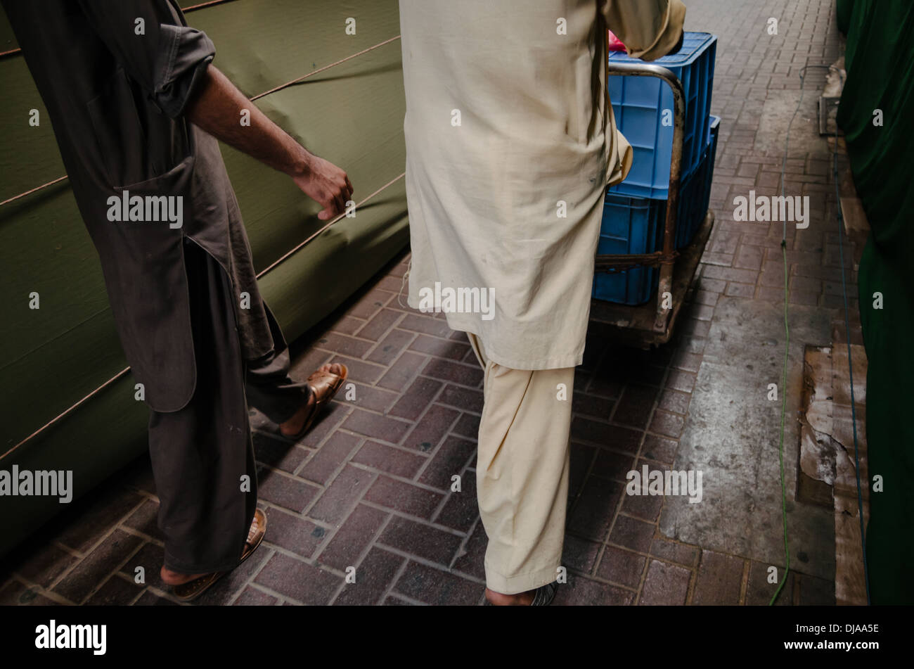Two Arab men pushing a cart through the streets of Deira. Dubai, United ...