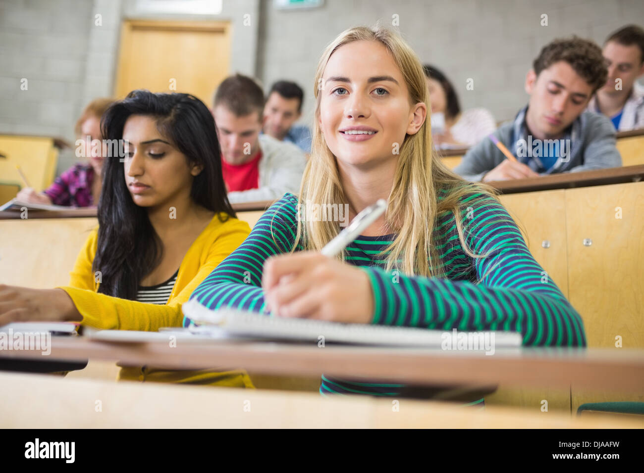 Students writing notes in lecture hall Stock Photo - Alamy