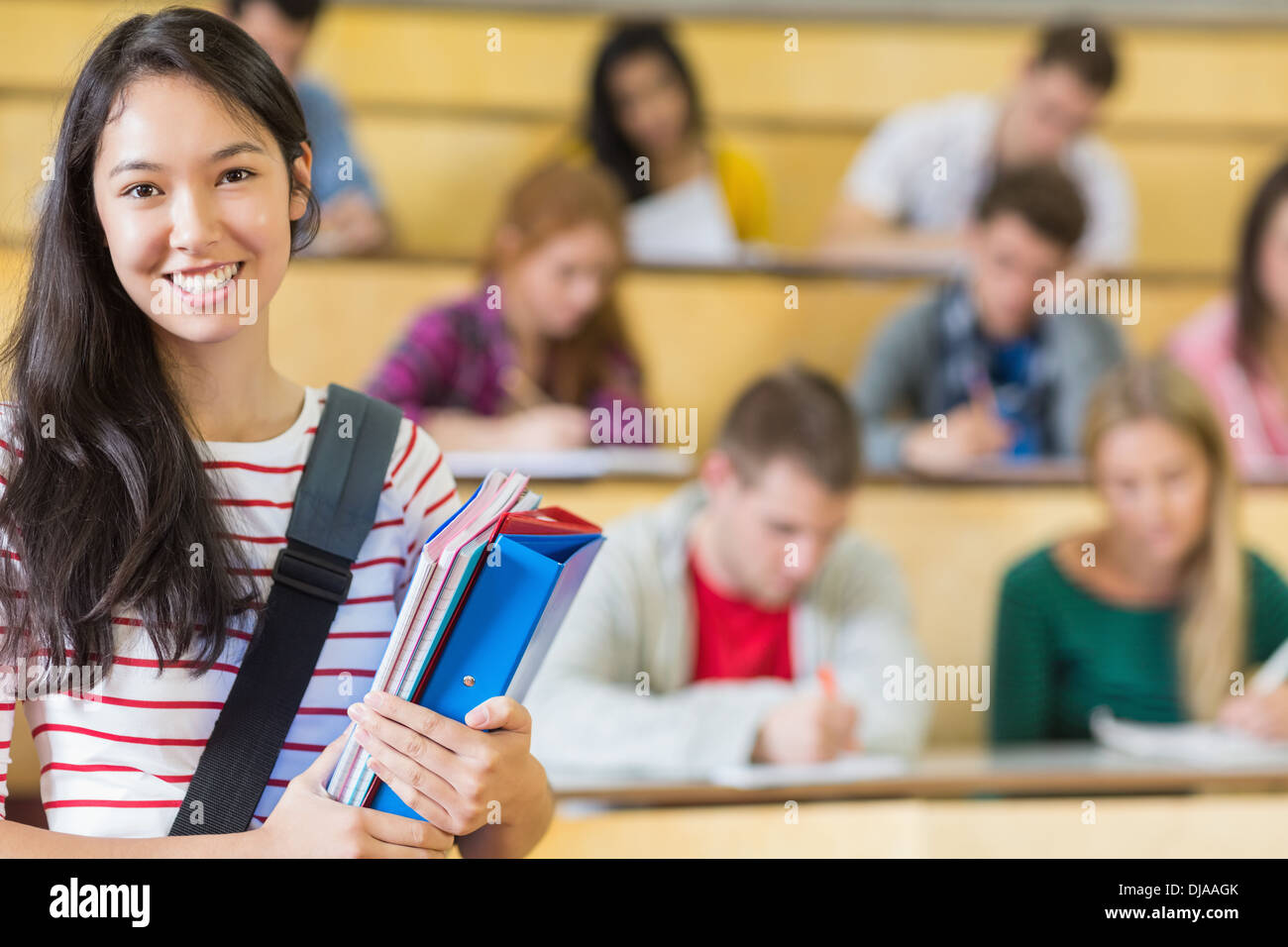 Smiling female with students sitting at the lecture hall Stock Photo ...