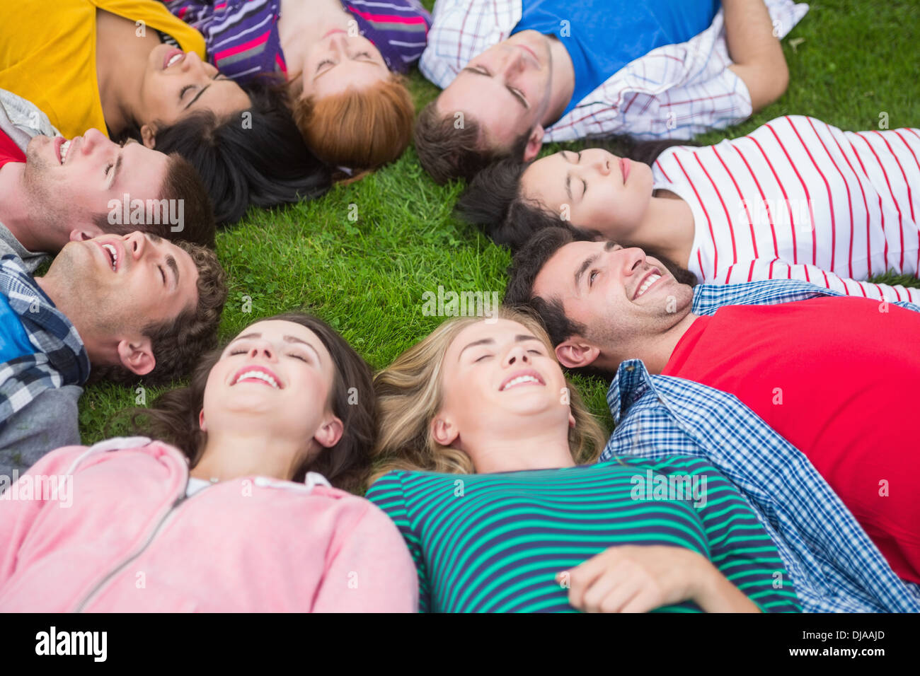 Group of friends lying down in park Stock Photo - Alamy
