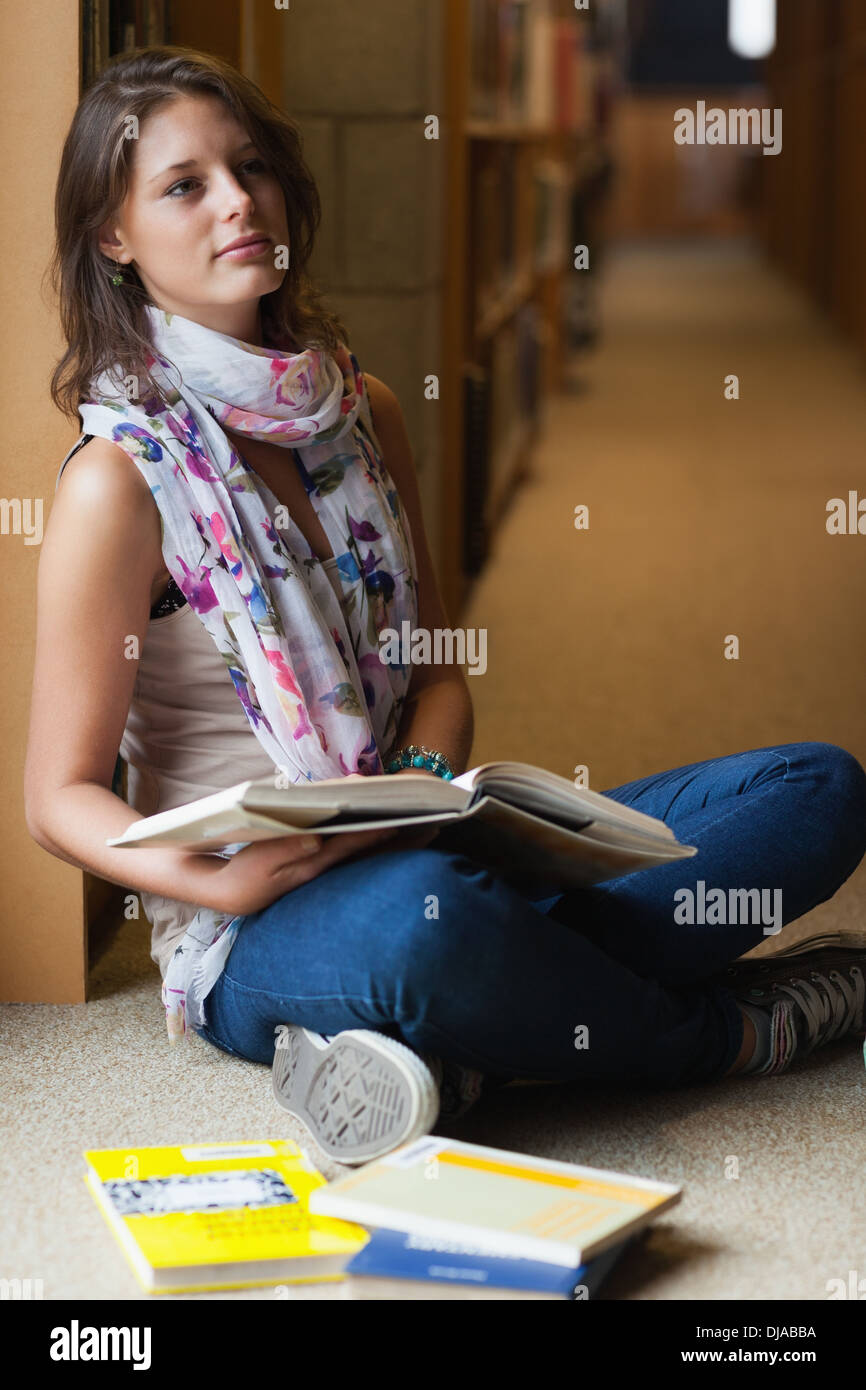 Thoughtful student sitting with books in the library Stock Photo - Alamy