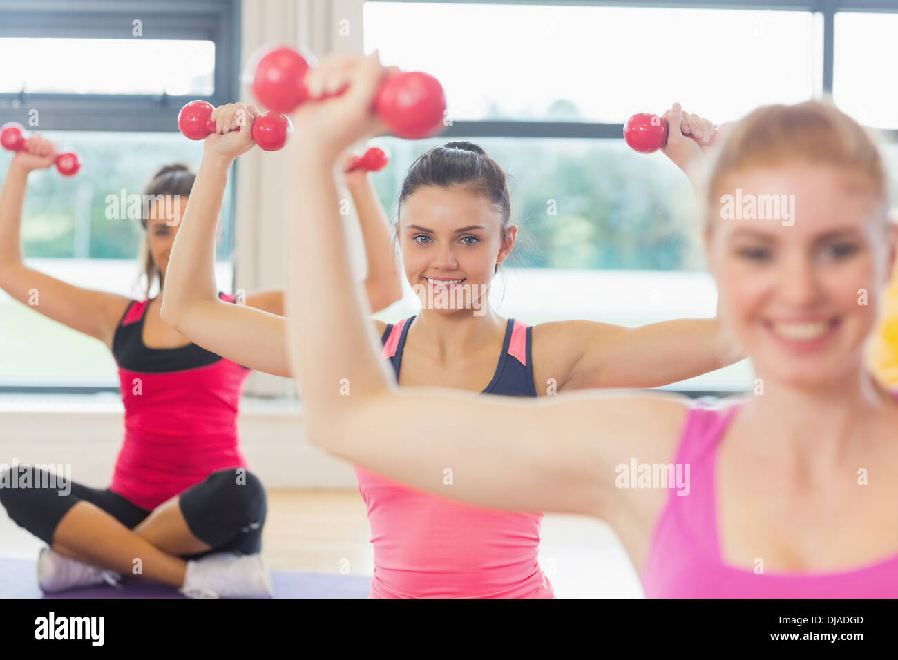 Fitness class and trainer lifting dumbbells Stock Photo - Alamy