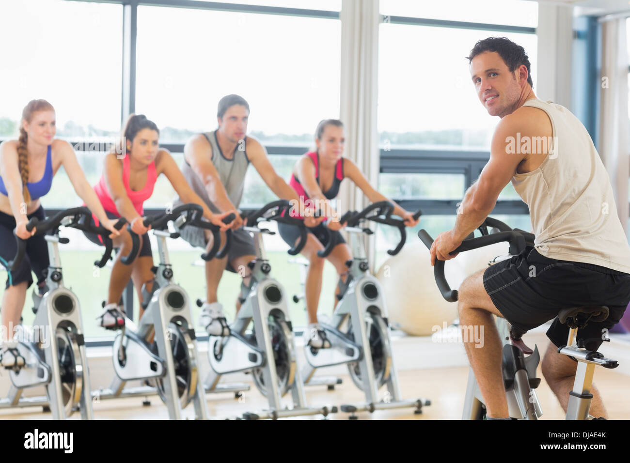 Man teaching spinning class to four people Stock Photo - Alamy