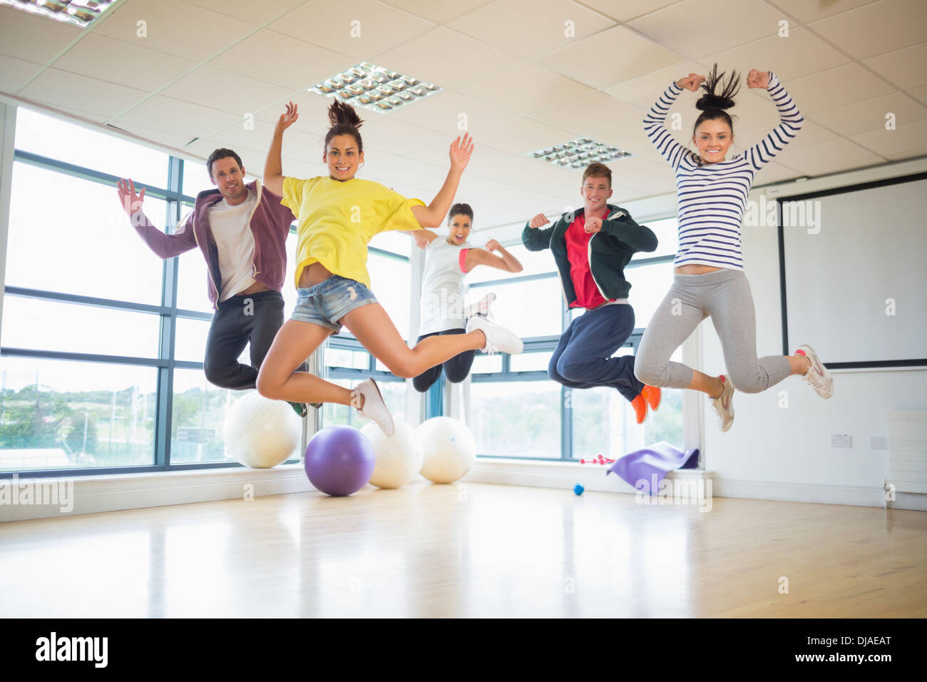 Fit people jumping in bright exercise room Stock Photo - Alamy