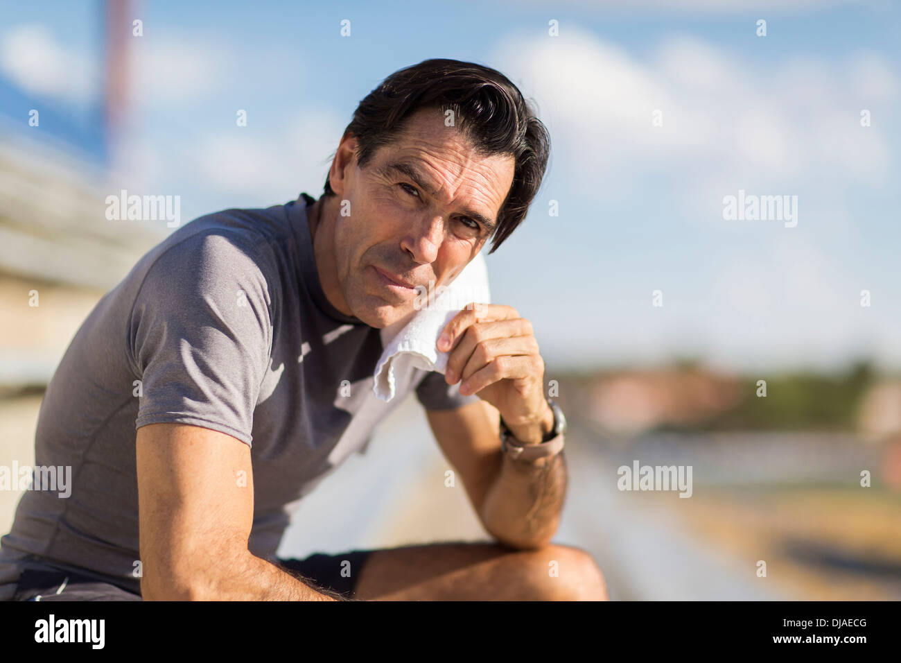 Hispanic man resting with towel around neck Stock Photo - Alamy