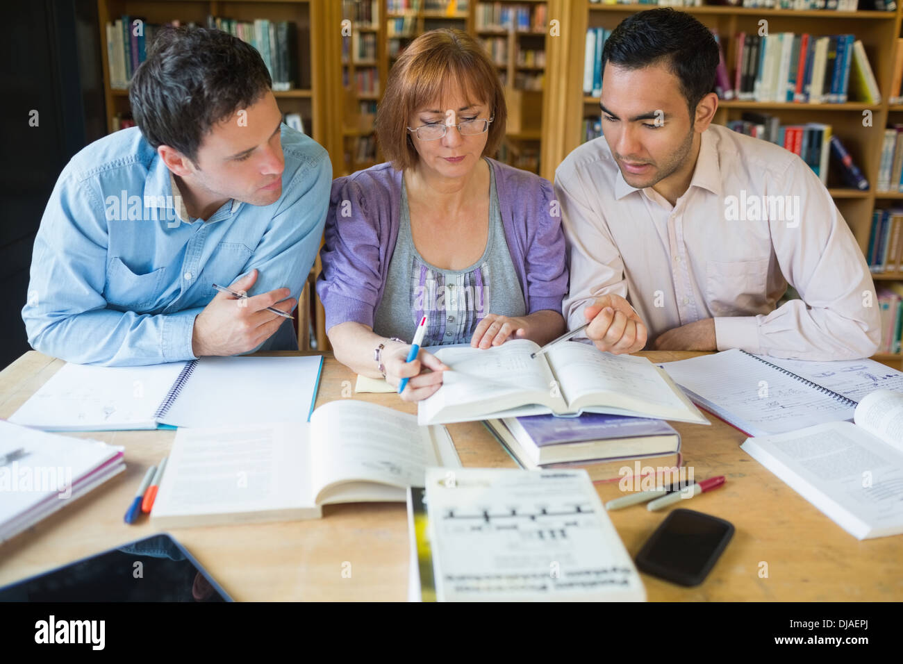 Adult students studying together in the library Stock Photo - Alamy