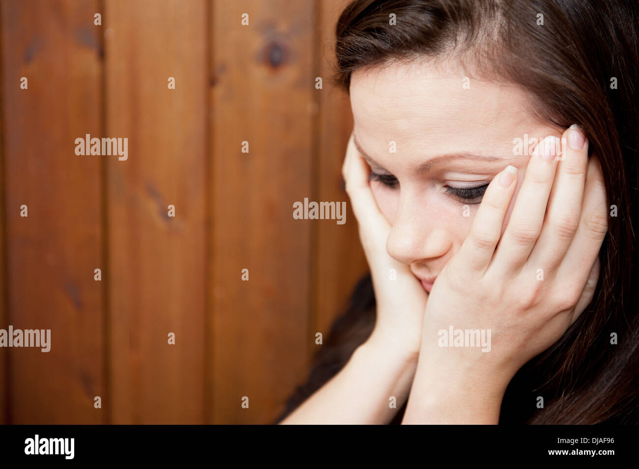 Upset young woman with her eye make-up running down her face from ...