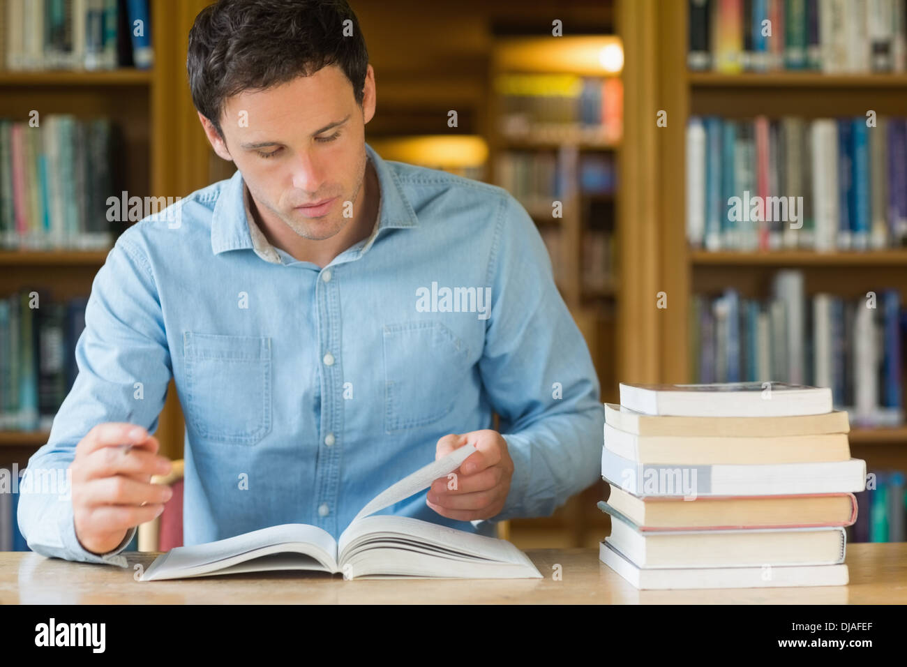 Serious mature student studying at library desk Stock Photo - Alamy