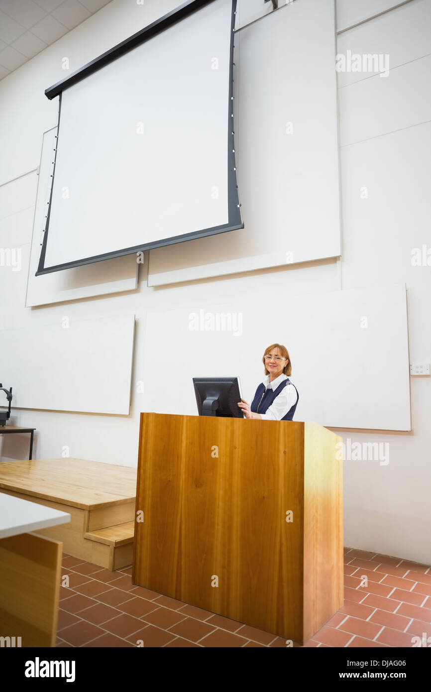 Teacher with computer and projection screen in lecture hall Stock Photo ...