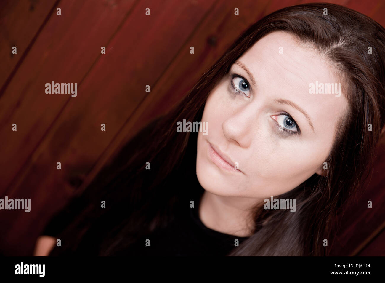 Upset looking young woman with her eye make-up running down her face ...