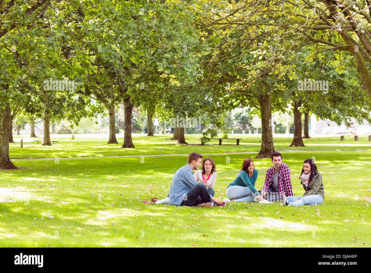 College friends sitting in lawn hi-res stock photography and images - Alamy