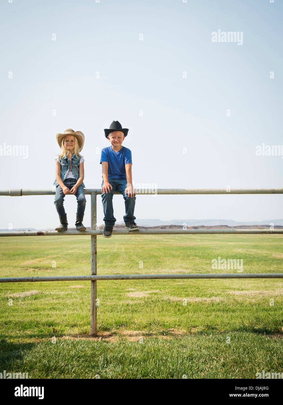 Caucasian children sitting on fence on farm Stock Photo - Alamy