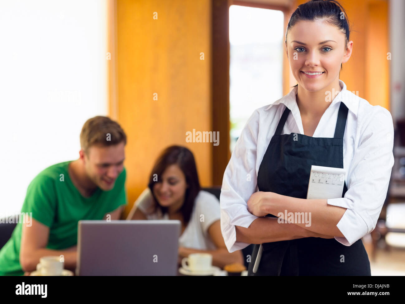 Waitress with two students using laptop at coffee shop Stock Photo - Alamy