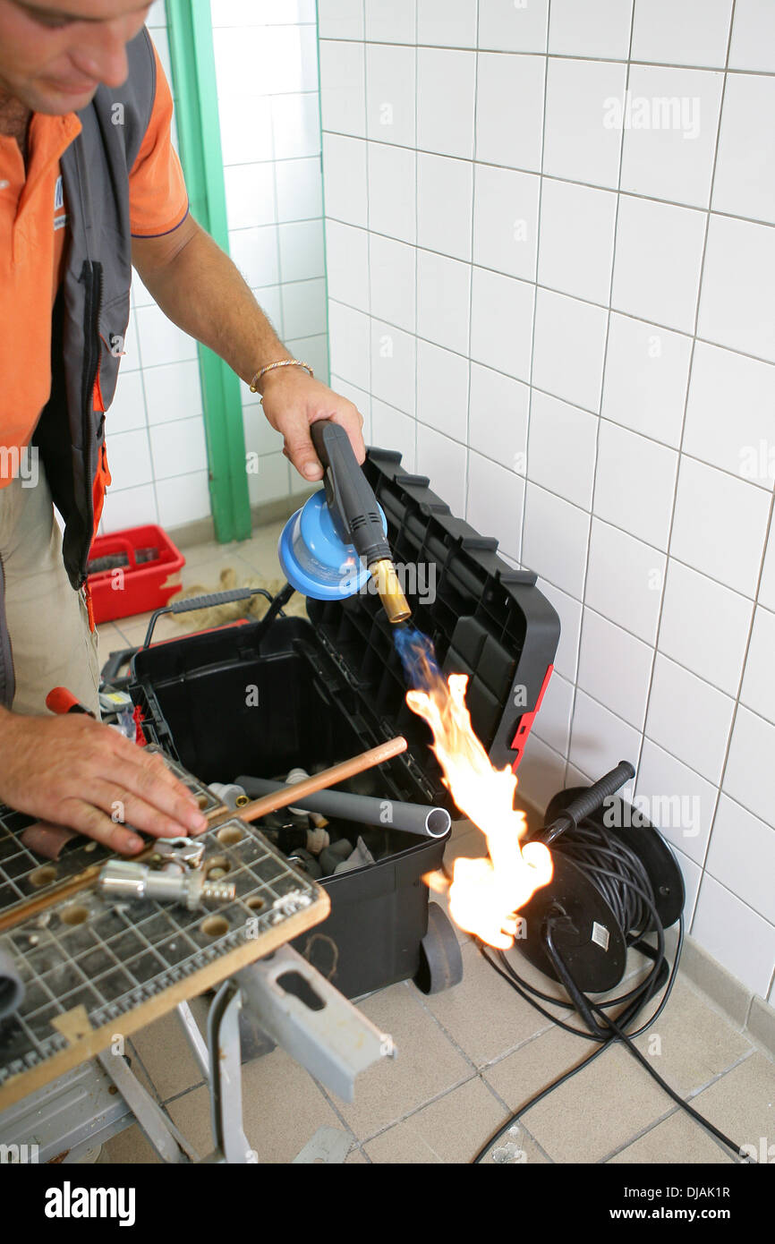 Plumber heating up copper pipe Stock Photo - Alamy