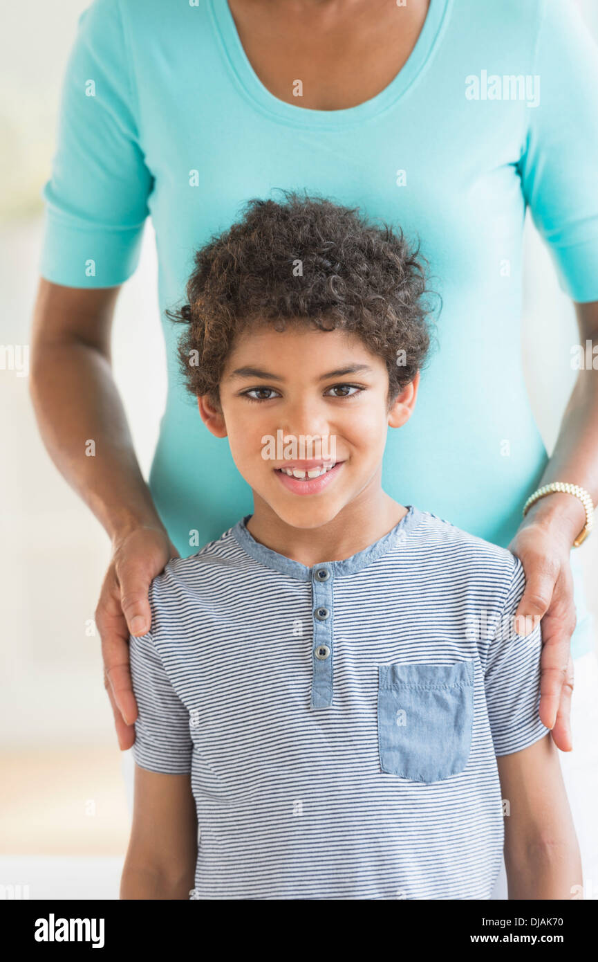 Smiling boy standing with mother Stock Photo - Alamy