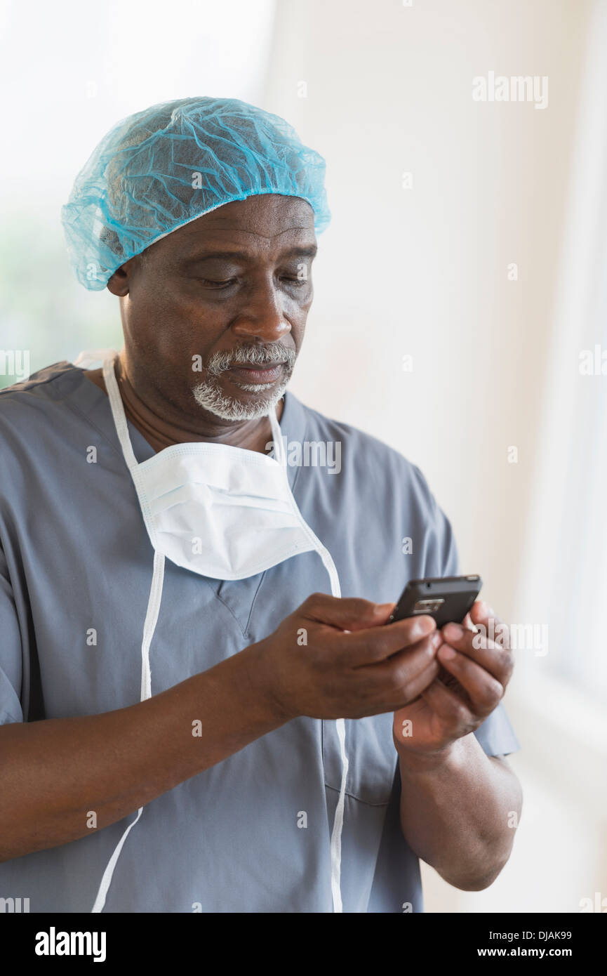 Black surgeon using cell phone Stock Photo - Alamy