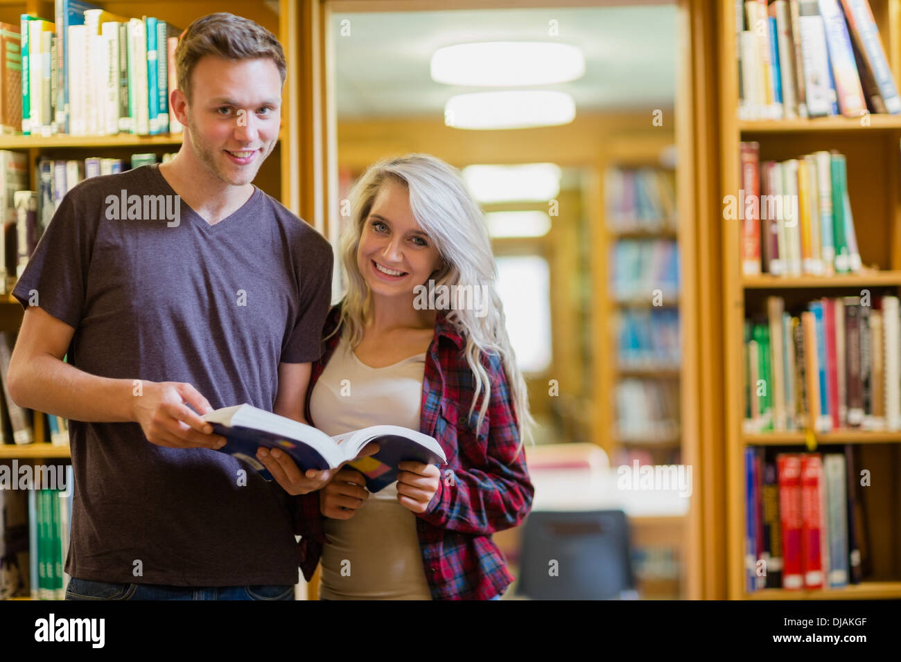 Portrait of two students reading book in the library Stock Photo - Alamy