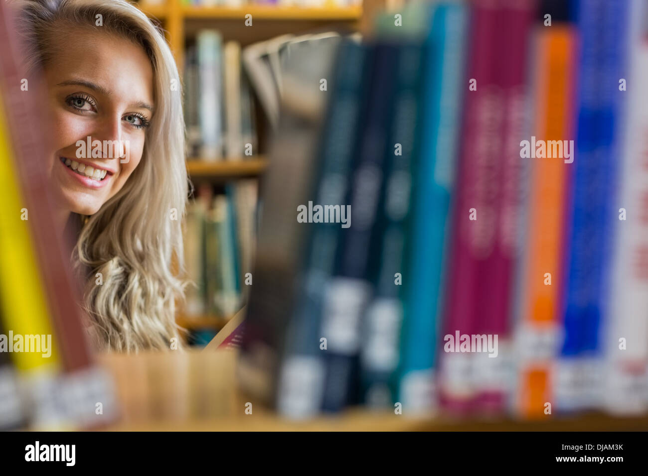 Smiling female amid bookshelves in the college library Stock Photo - Alamy