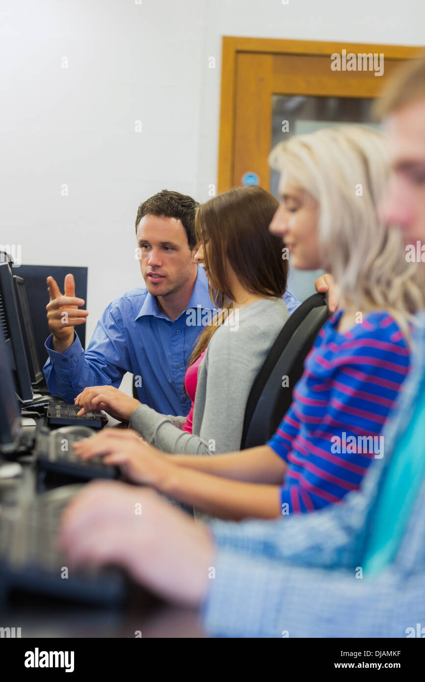 Teacher explaining to students in the computer room Stock Photo - Alamy