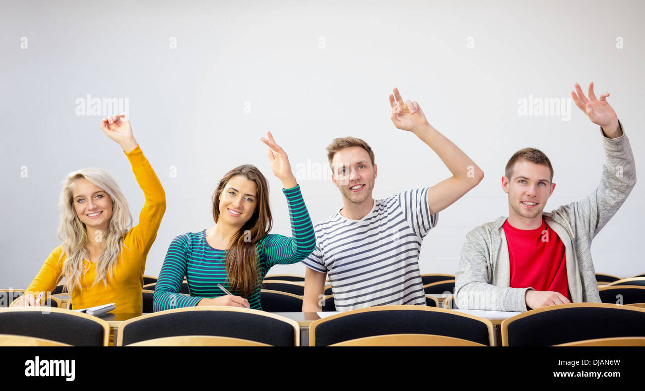 College students raising hands in the classroom Stock Photo - Alamy