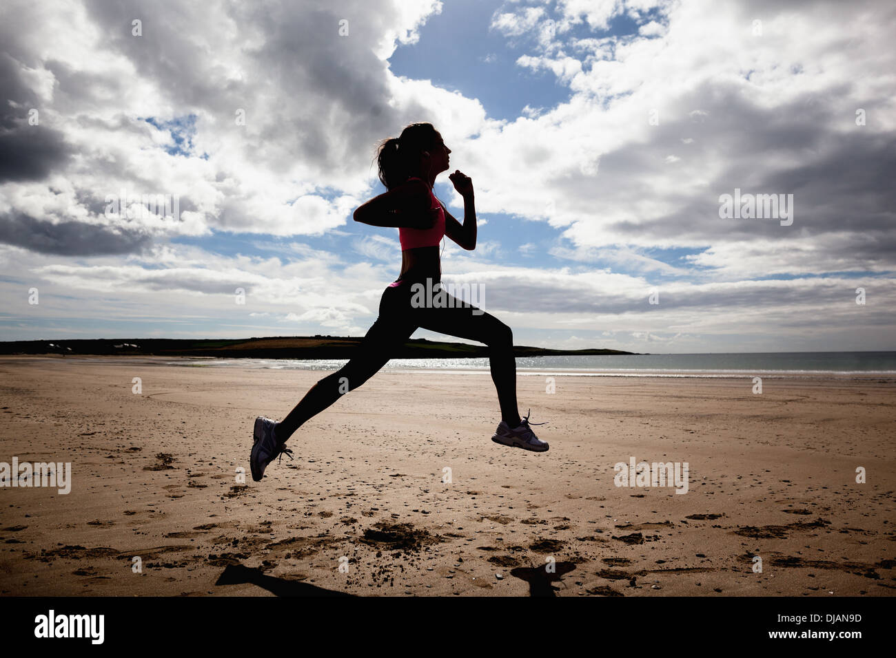 Full length of silhouette healthy woman jogging on beach Stock Photo ...