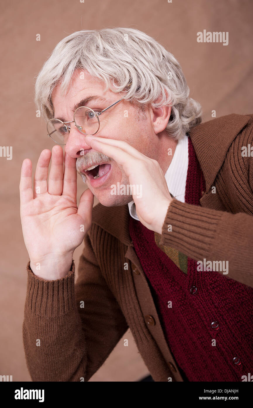 Grey haired old man using his hands to amplify his voice Stock Photo ...