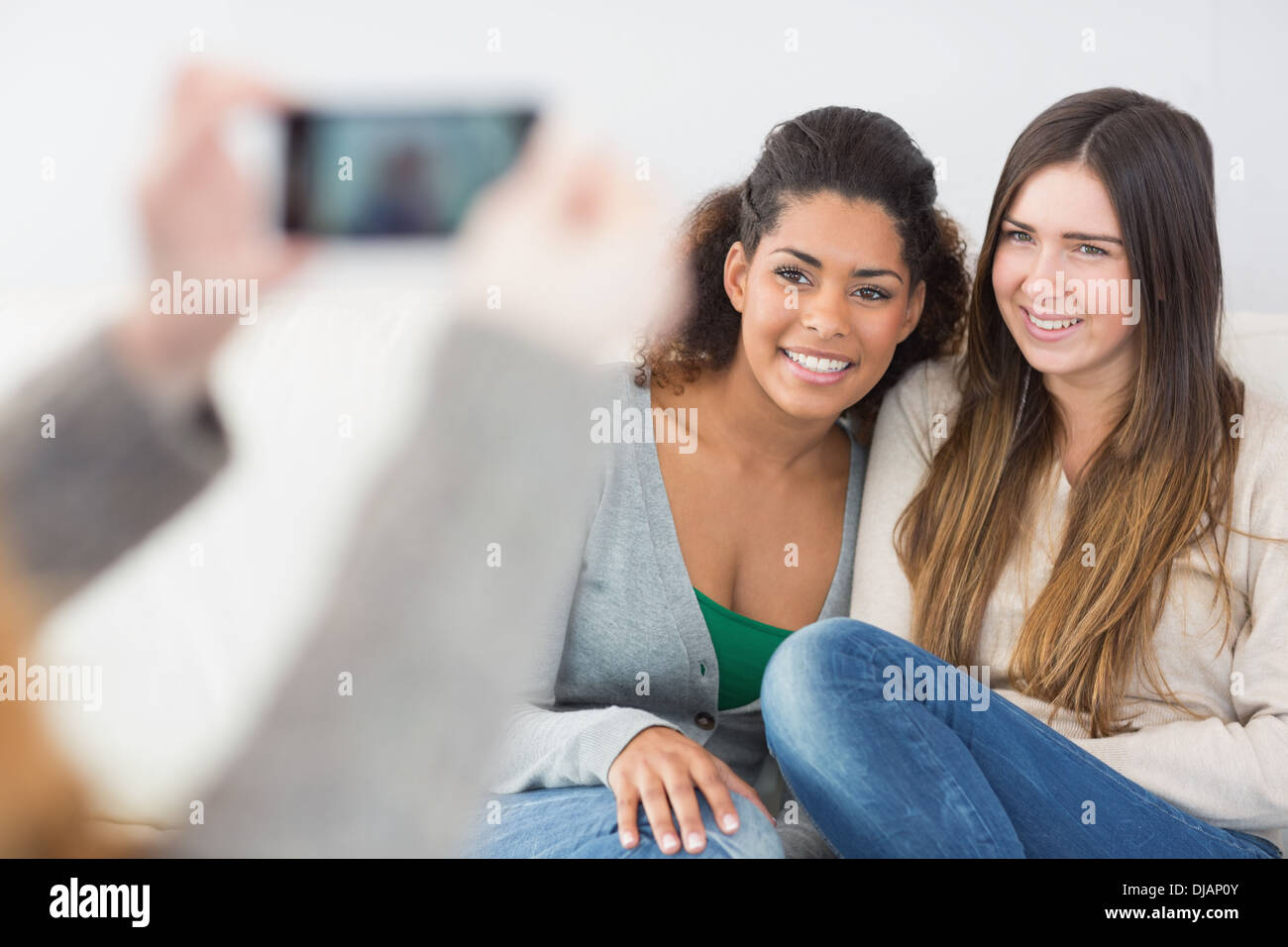 Woman photographing friends with smartphone Stock Photo - Alamy