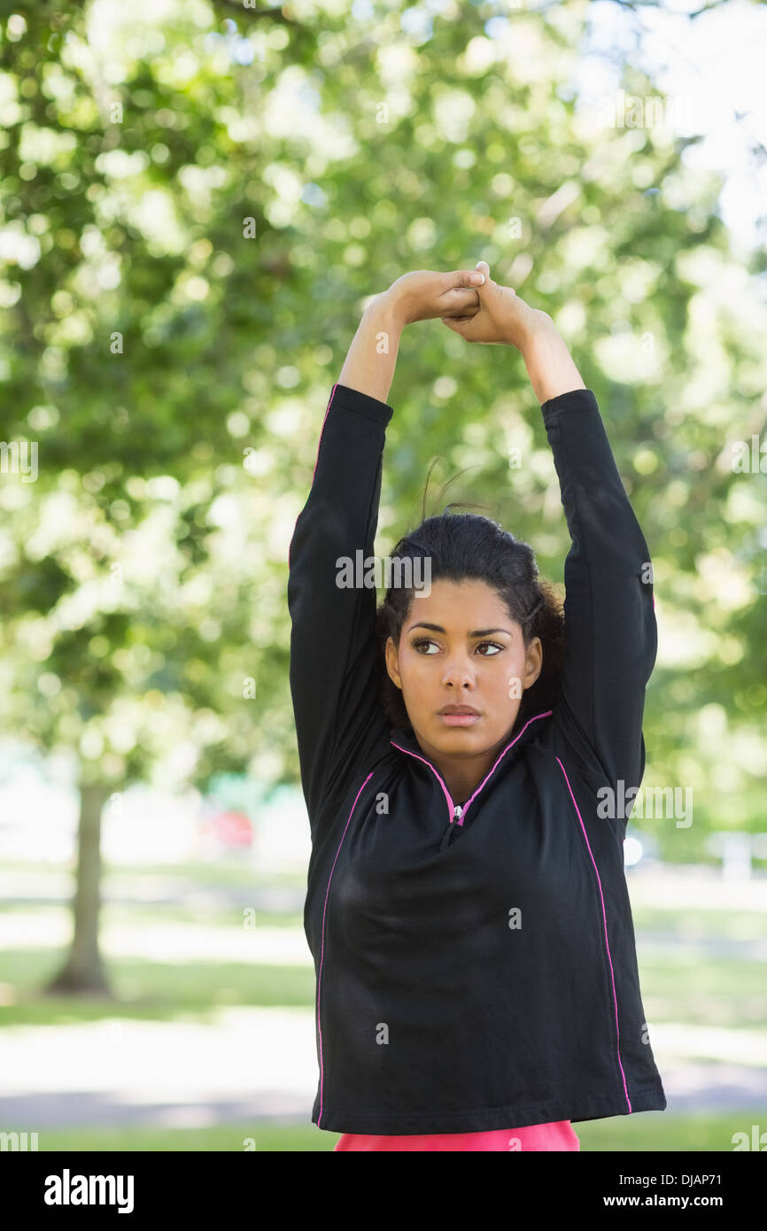 Woman stretching her hands during exercise at park Stock Photo - Alamy