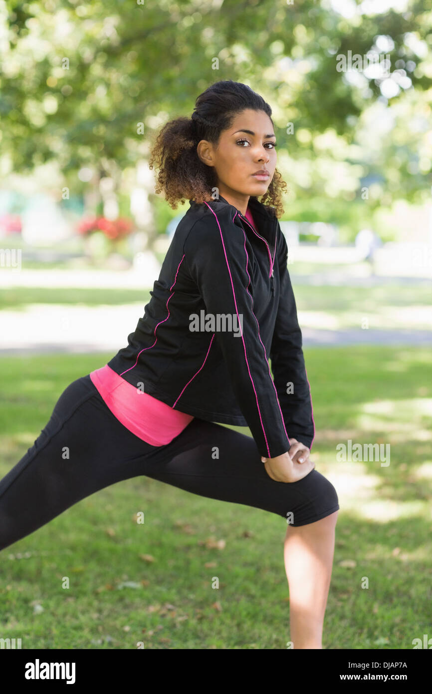 Serious young woman stretching legs hi-res stock photography and images ...