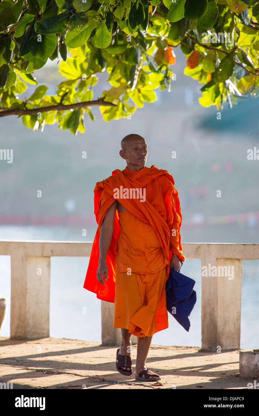 Buddhist monk walking along the banks of the Mekong river in Paske ...