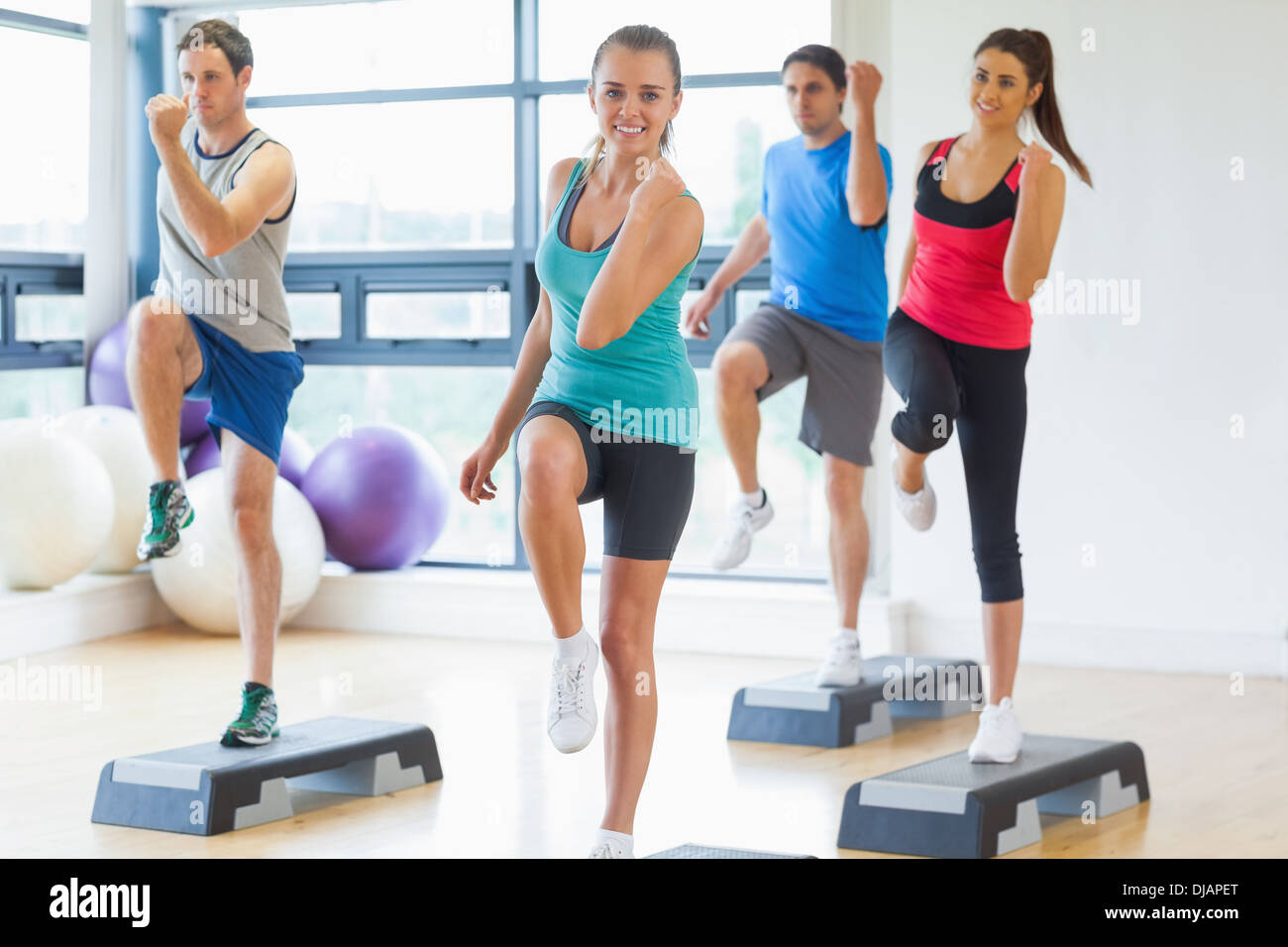 Instructor with fitness class performing step aerobics exercise Stock ...