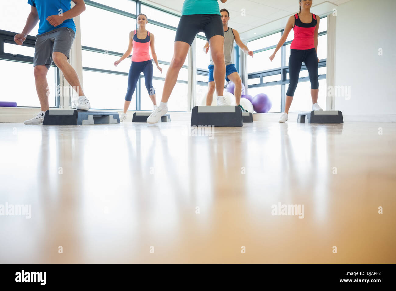 Instructor with fitness class performing step aerobics exercise Stock ...